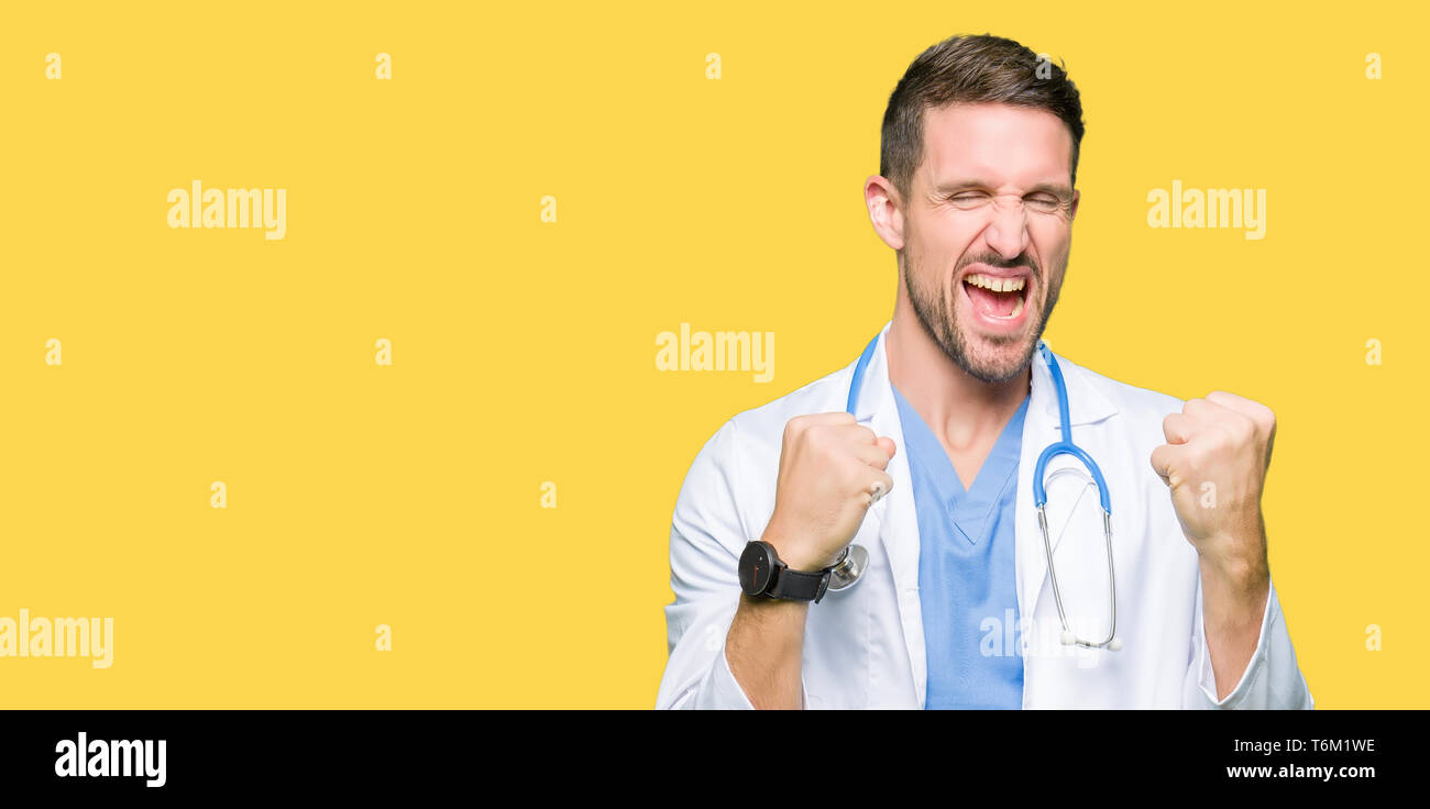 Handsome doctor man wearing medical uniform over isolated background ...