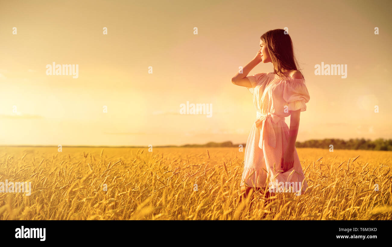 Young girl in wheat field at sunset Stock Photo - Alamy