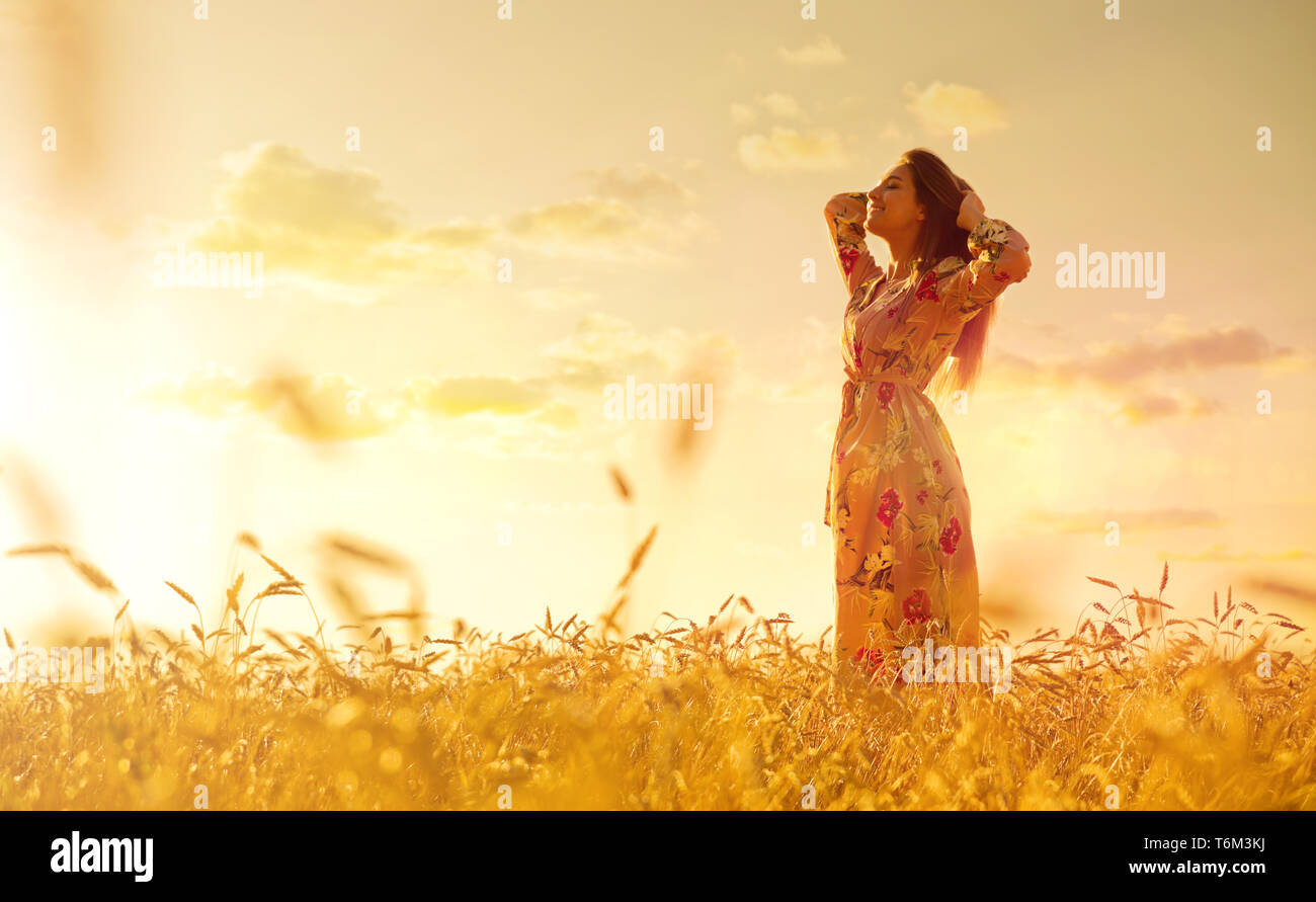 Young girl in wheat field at sunset Stock Photo - Alamy