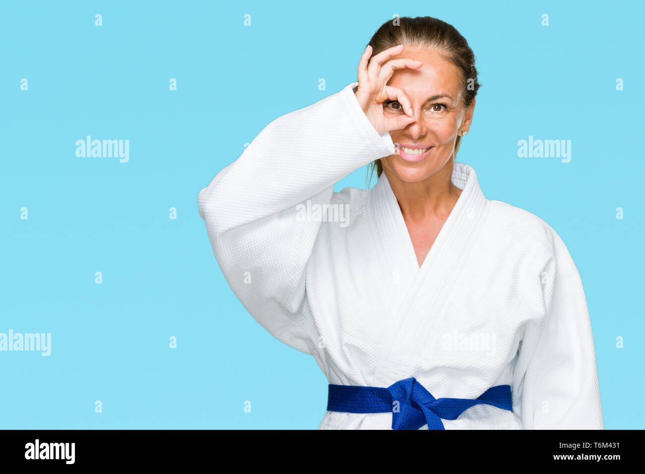 Middle age adult woman wearing karate kimono uniform over isolated ...