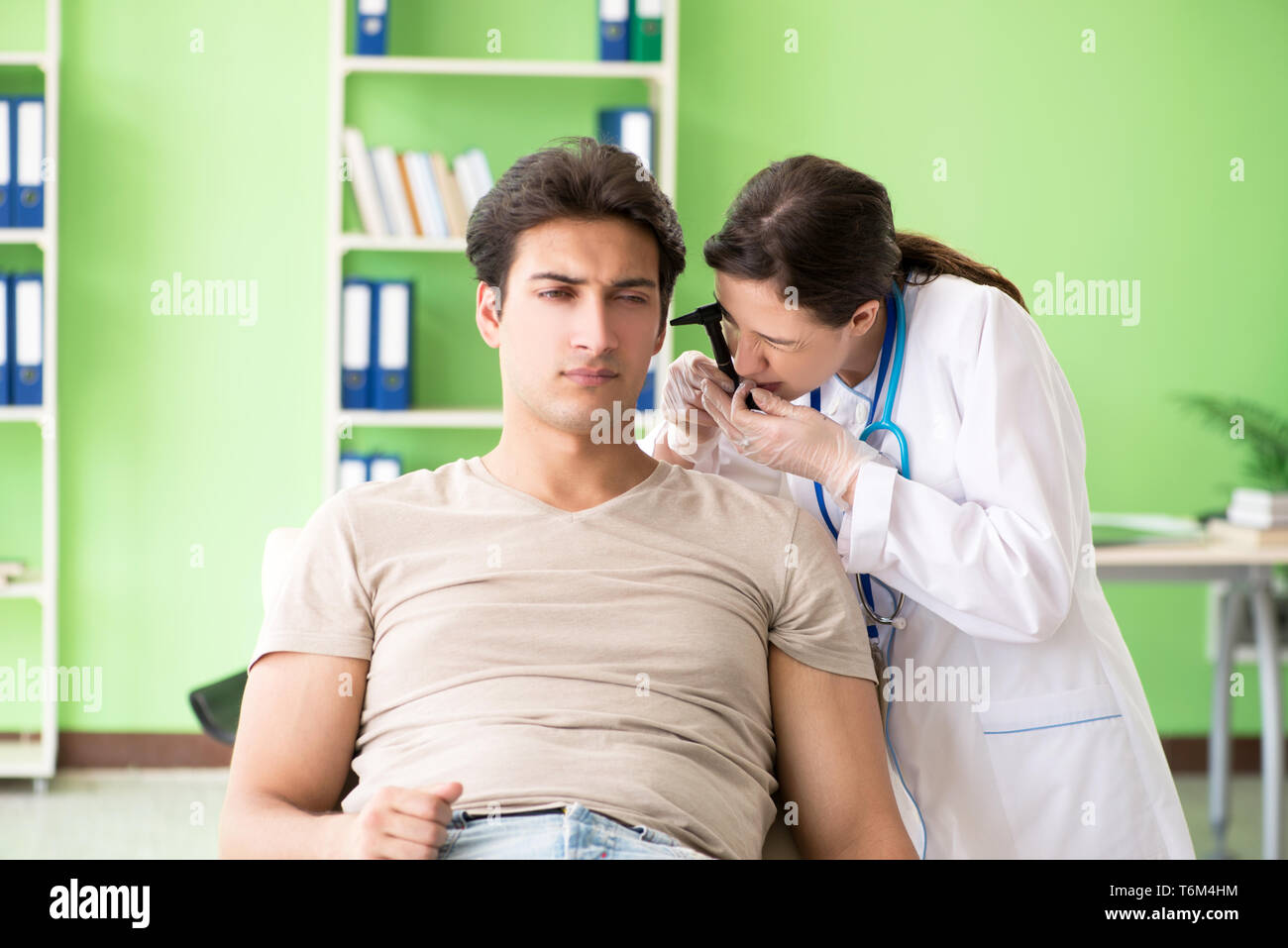 The female doctor checking patient's ear during medical examination ...