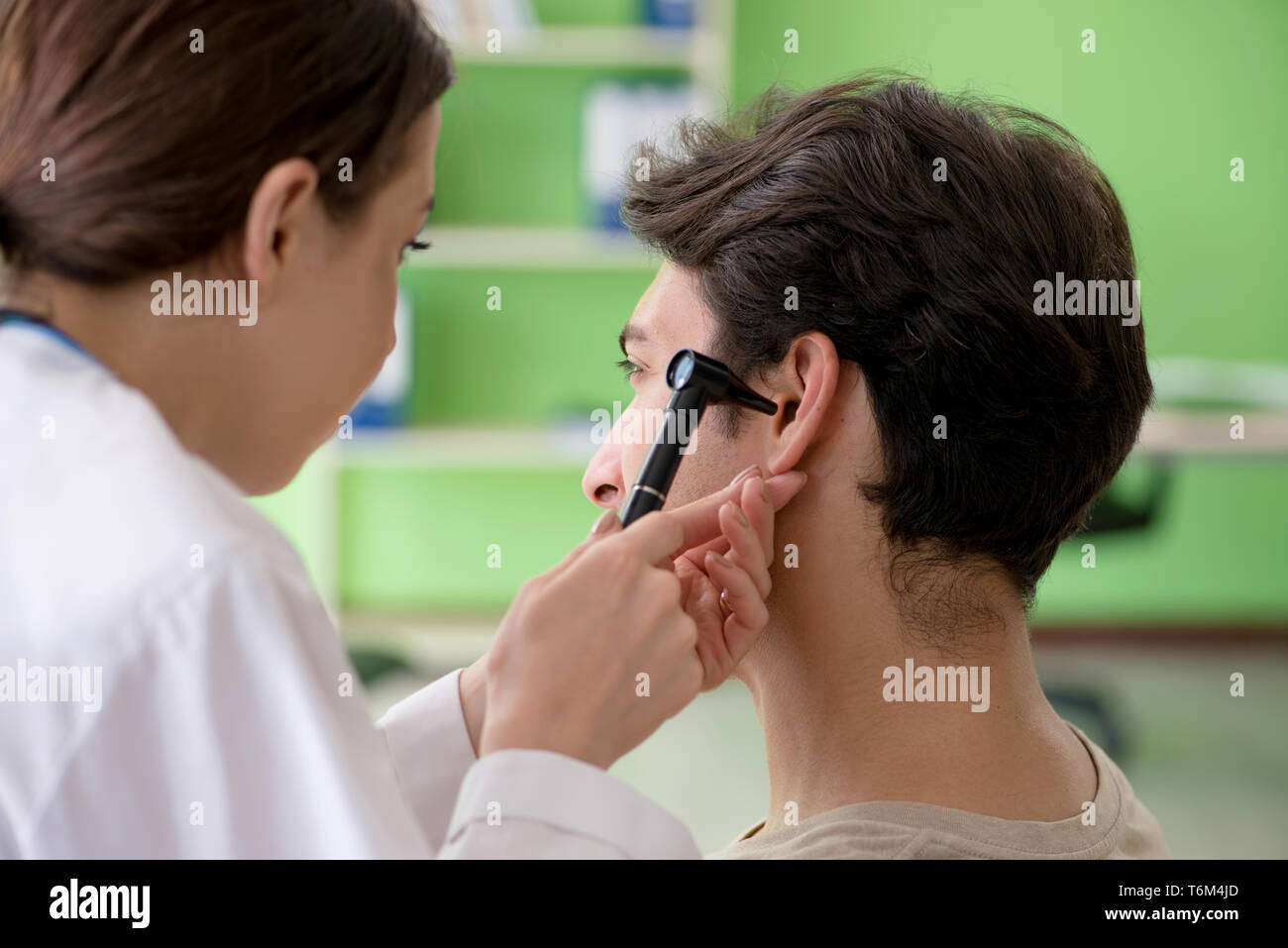 The female doctor checking patient's ear during medical examination ...