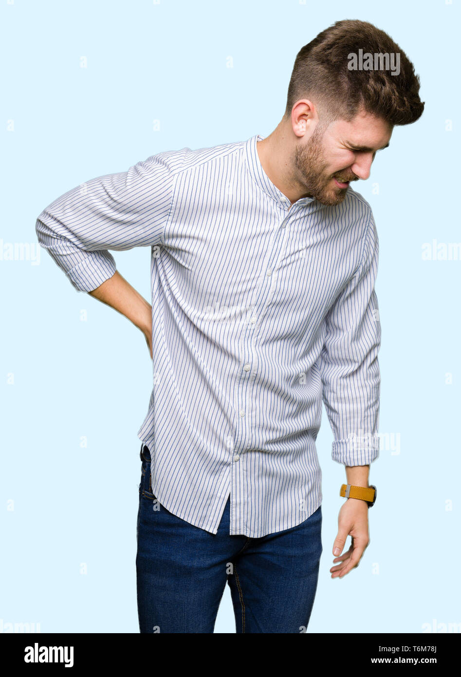 Young handsome man Suffering of backache, touching back with hand ...
