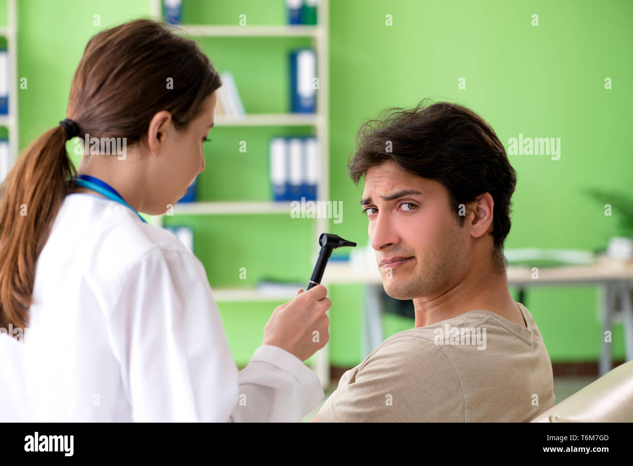 Female doctor checking patient's ear during medical examination Stock ...