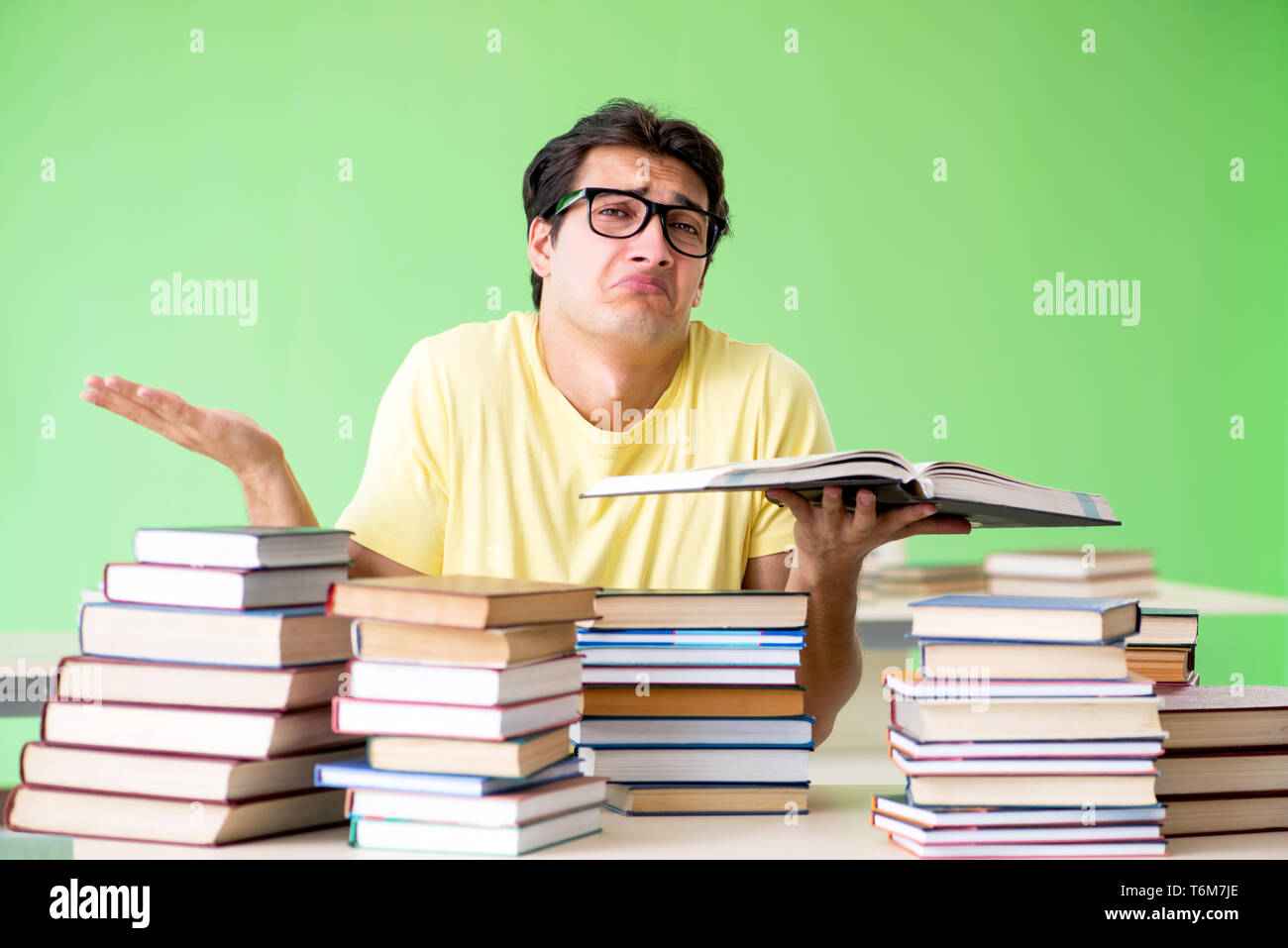 Student with too many books to read before exam Stock Photo - Alamy