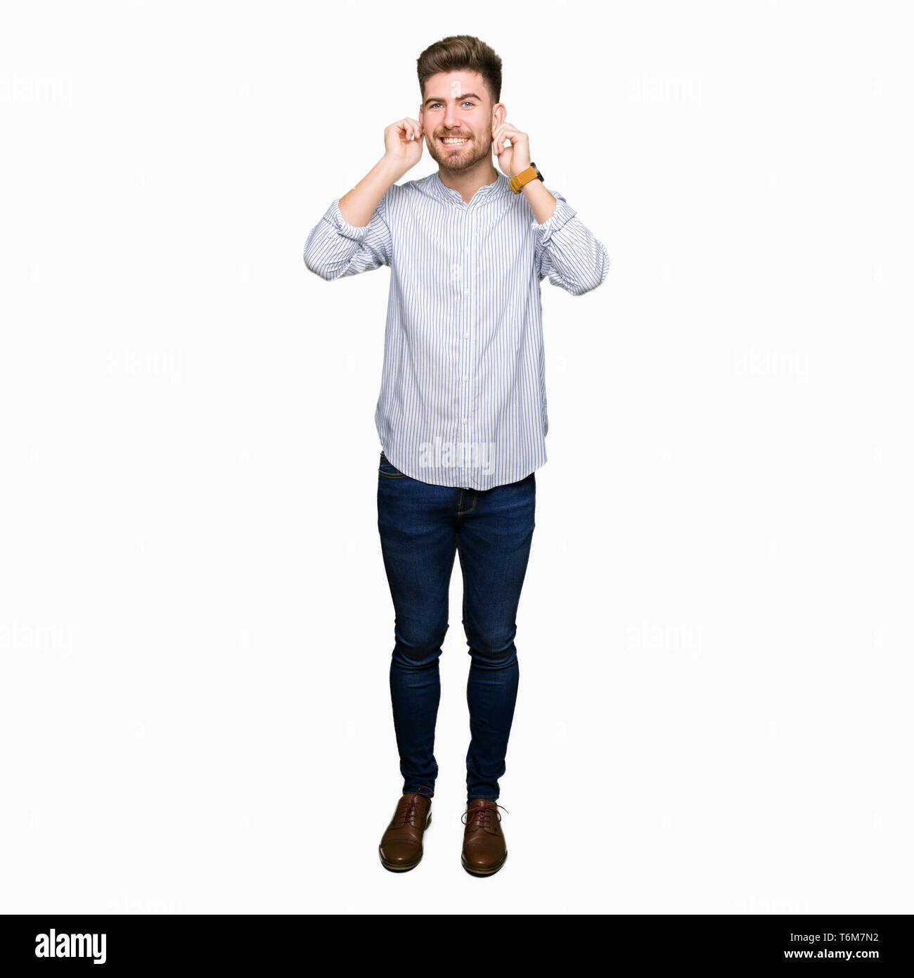 Young handsome man Smiling pulling ears with fingers, funny gesture ...