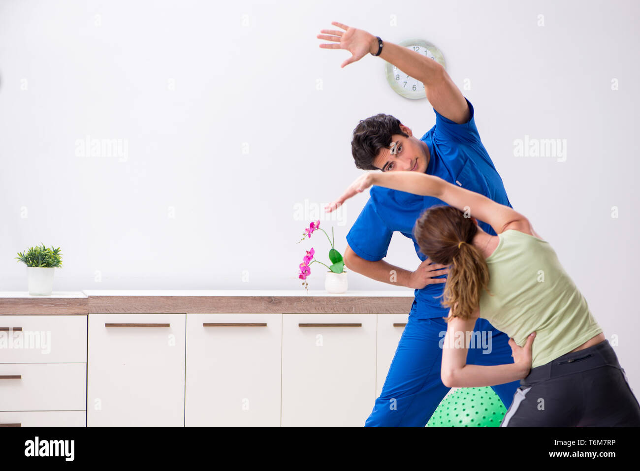 Fitness instructor helping sportsman during exercise Stock Photo - Alamy