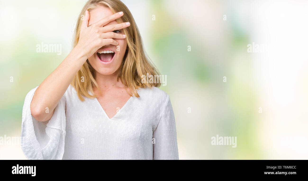 Beautiful young elegant woman over isolated background peeking in shock ...
