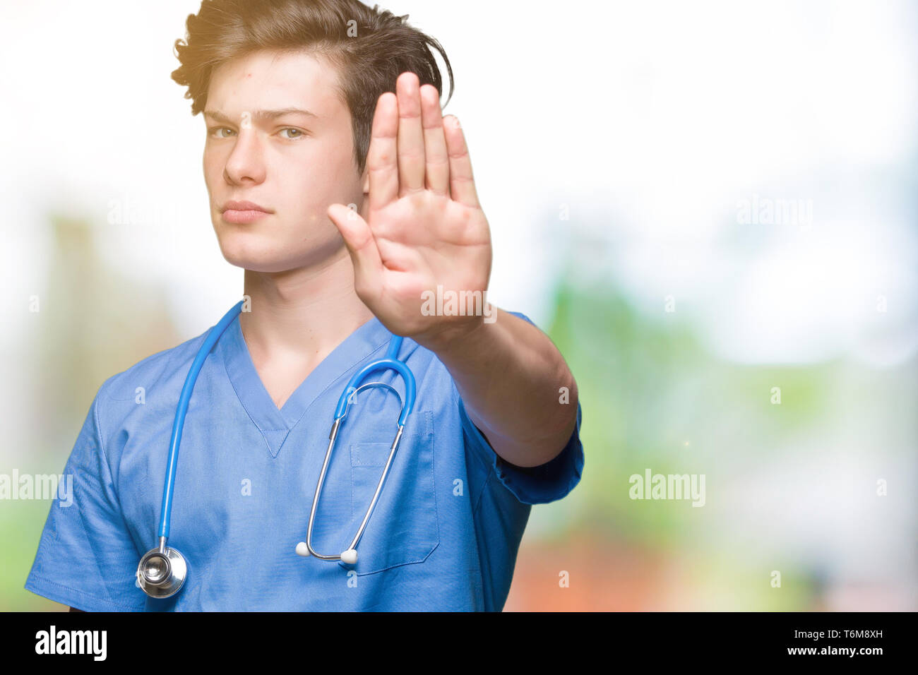 Young doctor wearing medical uniform over isolated background doing ...