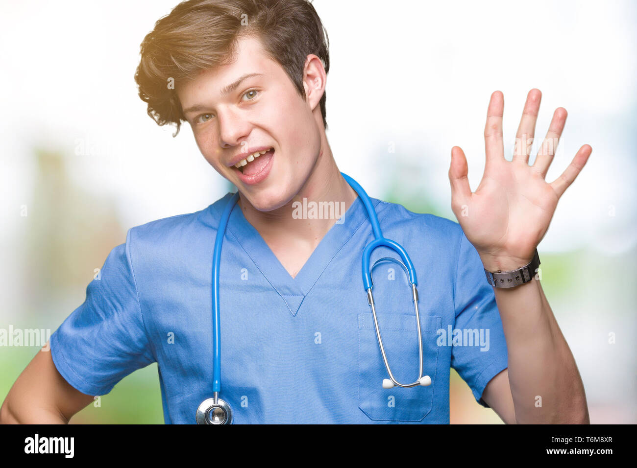 Young doctor wearing medical uniform over isolated background Waiving ...