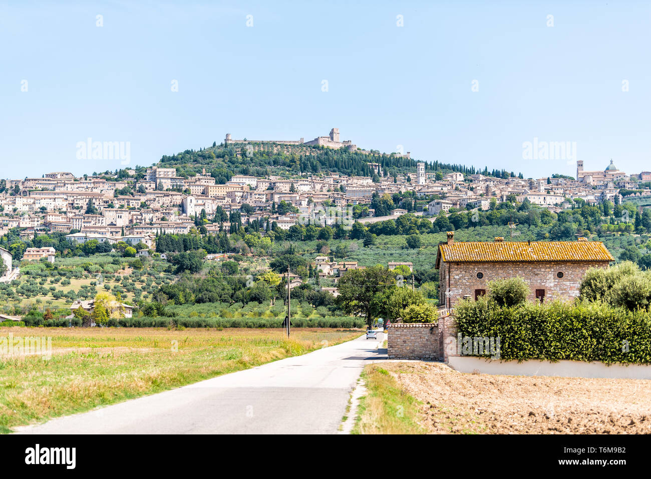 Road leading to village city of Assisi in Umbria, Italy cityscape of ...