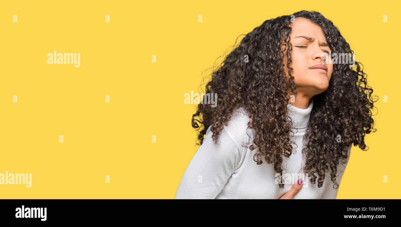 Young beautiful woman with curly hair wearing turtleneck sweater with ...