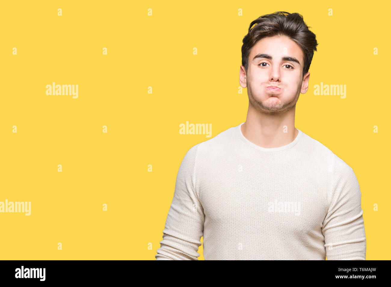 Young handsome man over isolated background puffing cheeks with funny ...
