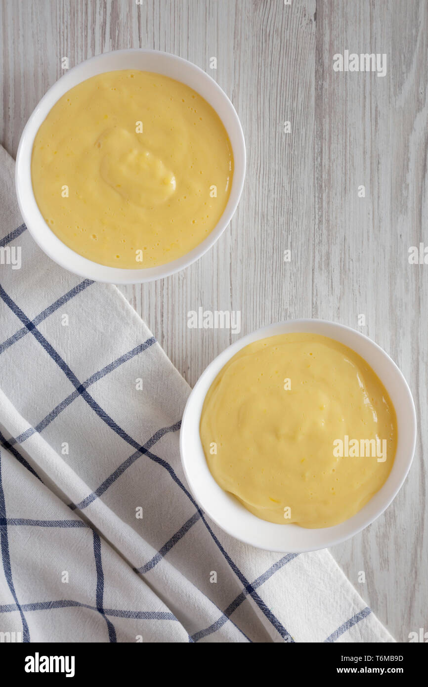 Homemade vanilla custard pudding in white bowls, top view. Overhead ...