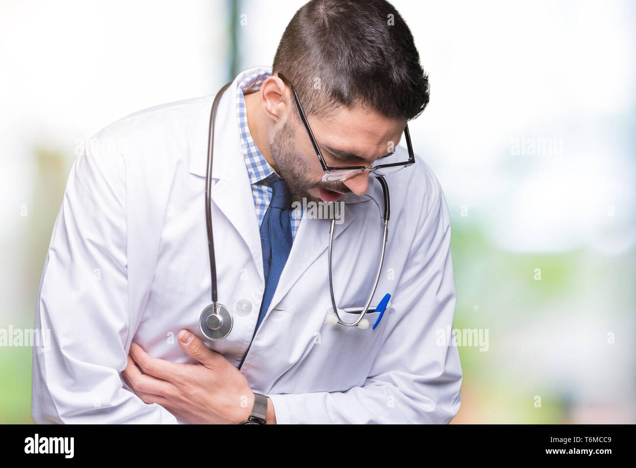 Handsome young doctor man over isolated background with hand on stomach ...