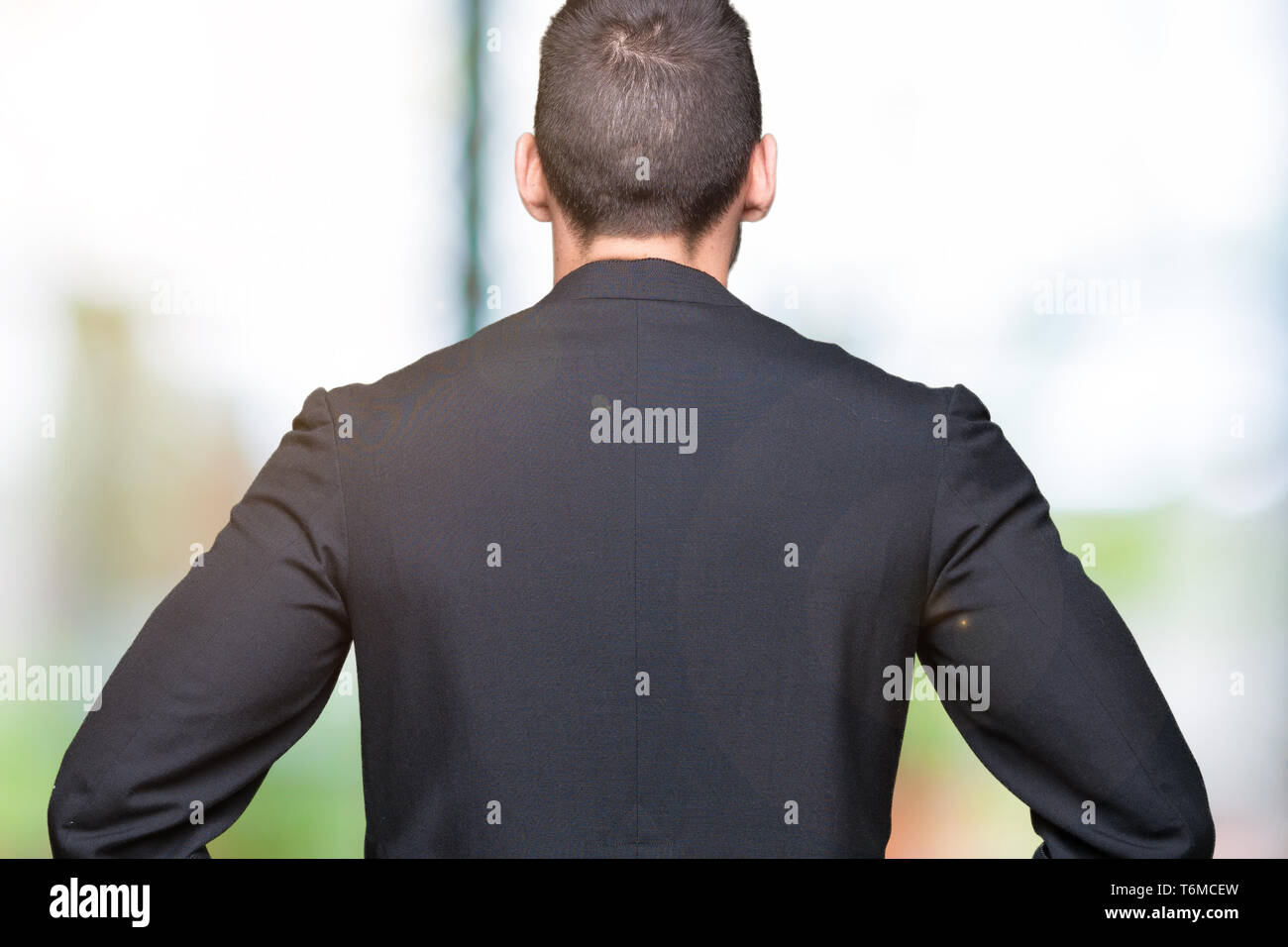 Young Christian priest over isolated background standing backwards ...