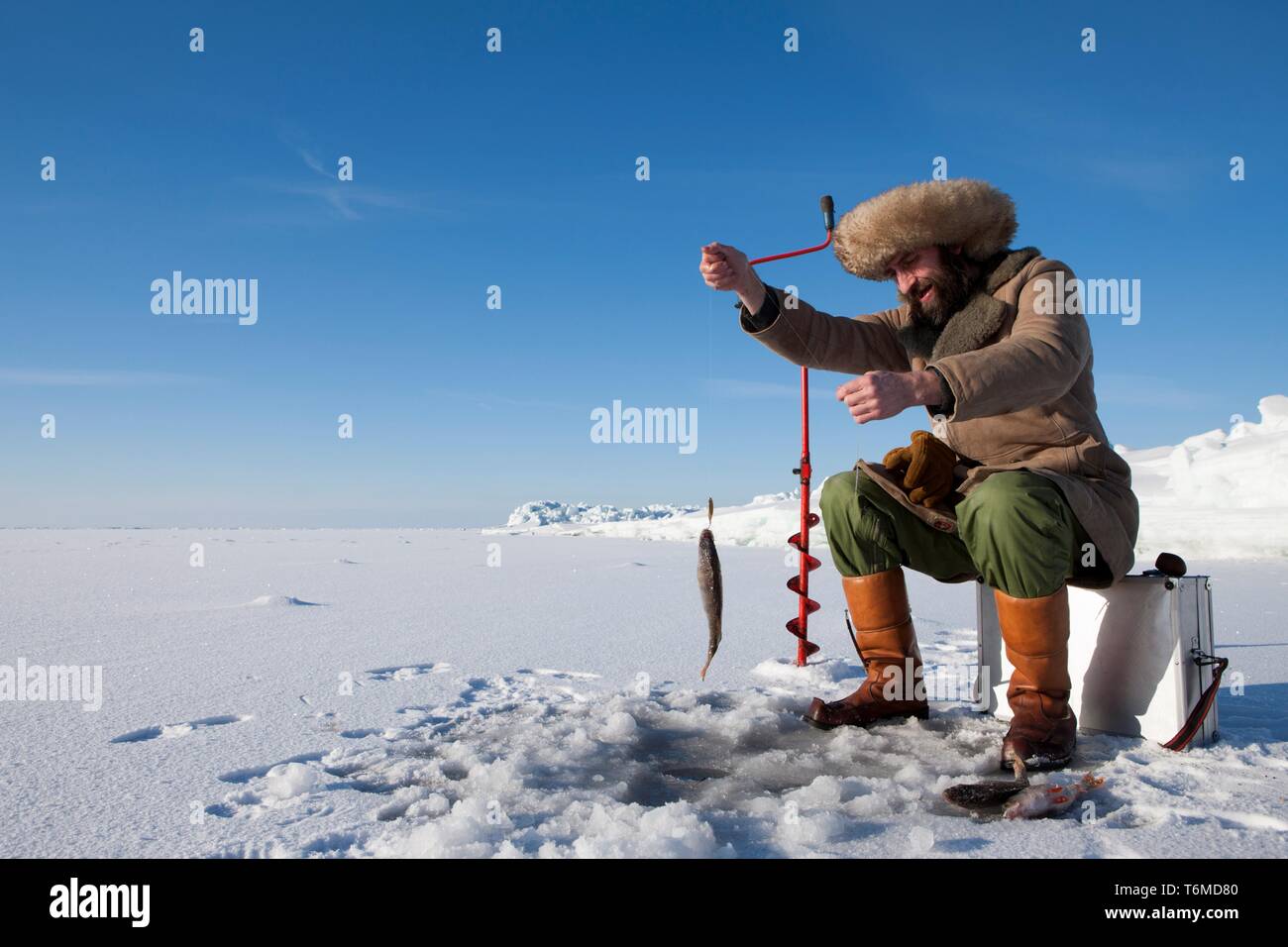 Man ice fishing Stock Photo - Alamy