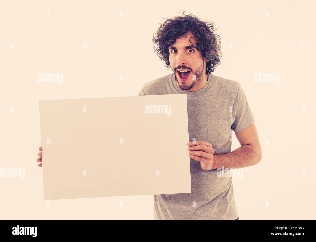 Funny and attractive millennial man showing blank poster with copy ...