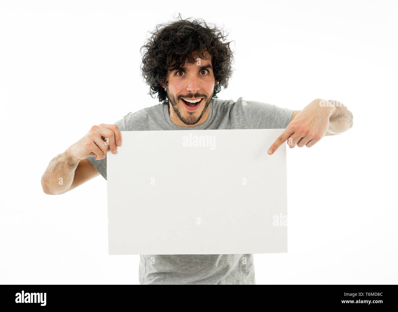Funny and attractive millennial man showing blank poster with copy ...