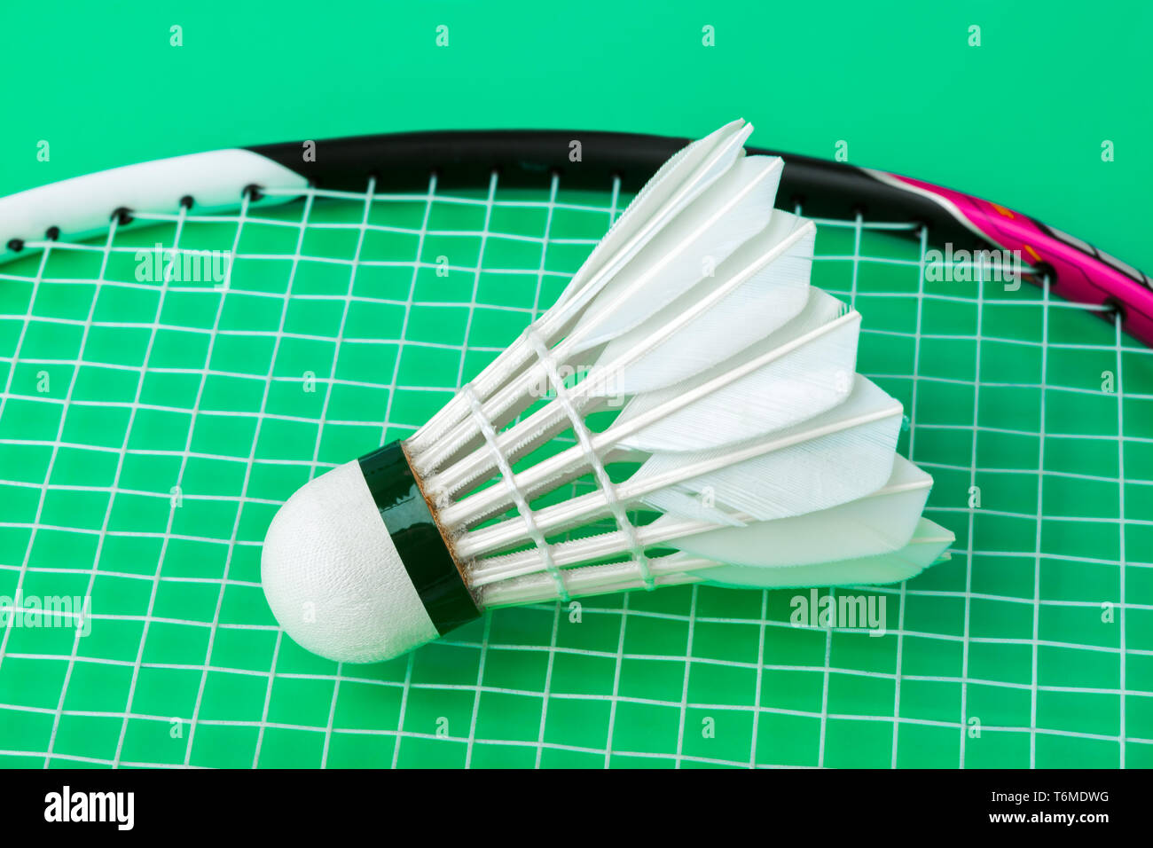 Badminton shuttlecock and racket on green background Stock Photo - Alamy