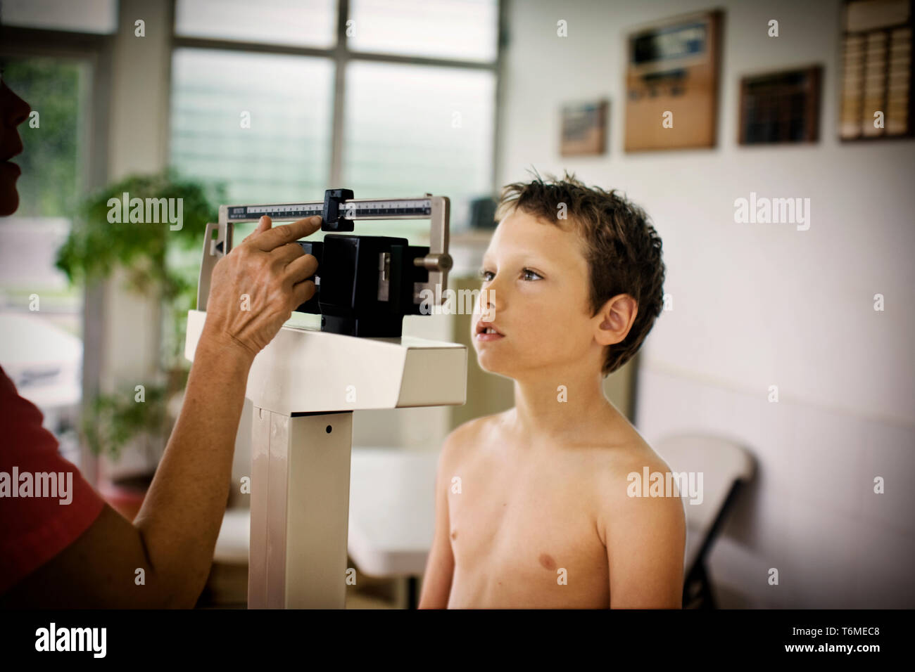 Young boy getting weighed on a scale Stock Photo - Alamy