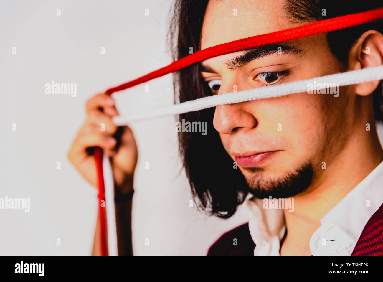 Portrait of young magician handling ropes and bandanas to do magic ...