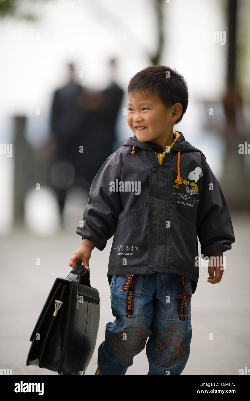 Smiling young boy carrying a suitcase Stock Photo - Alamy