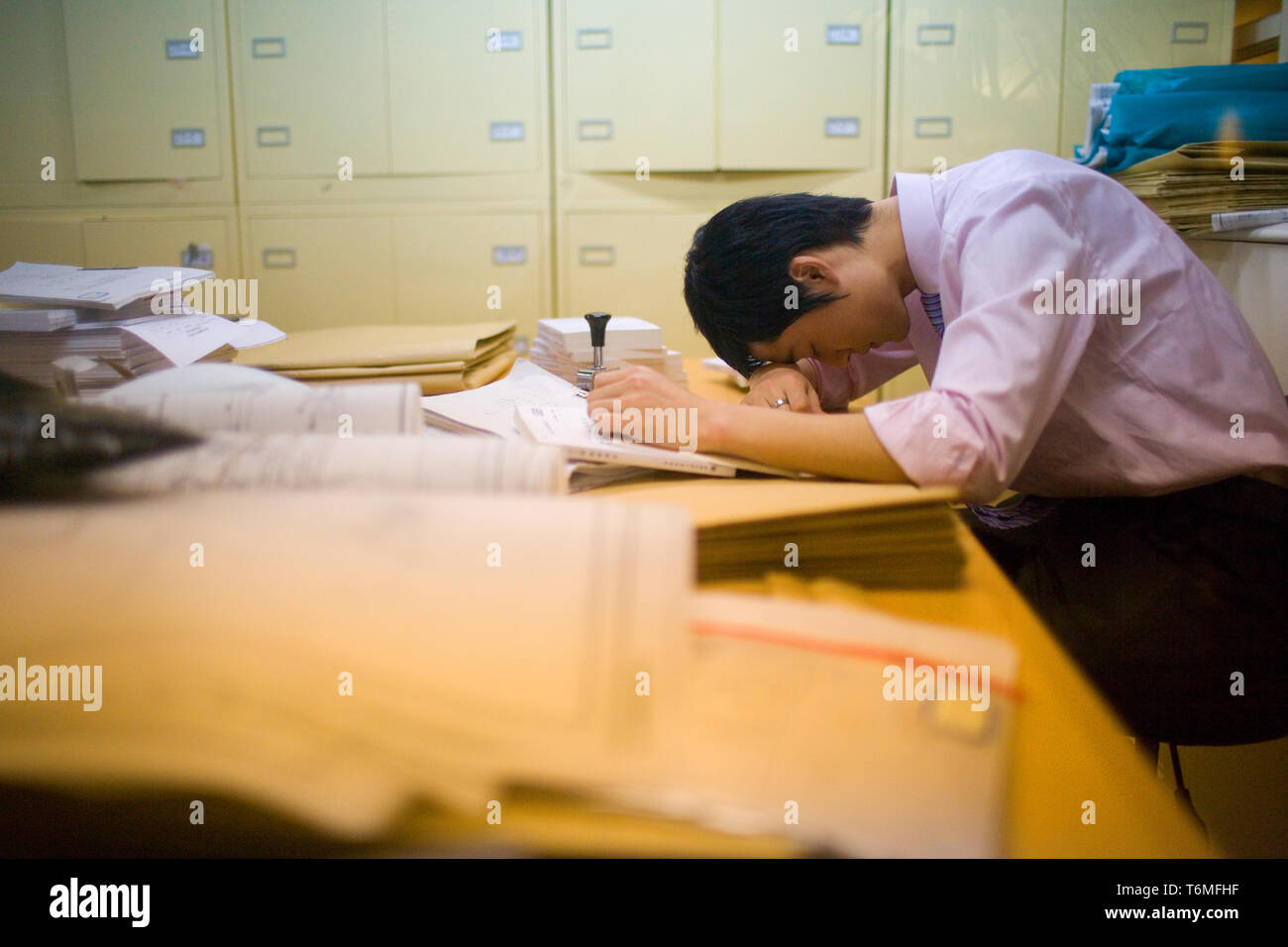 A man sitting with his head down on a desk hi-res stock photography and ...