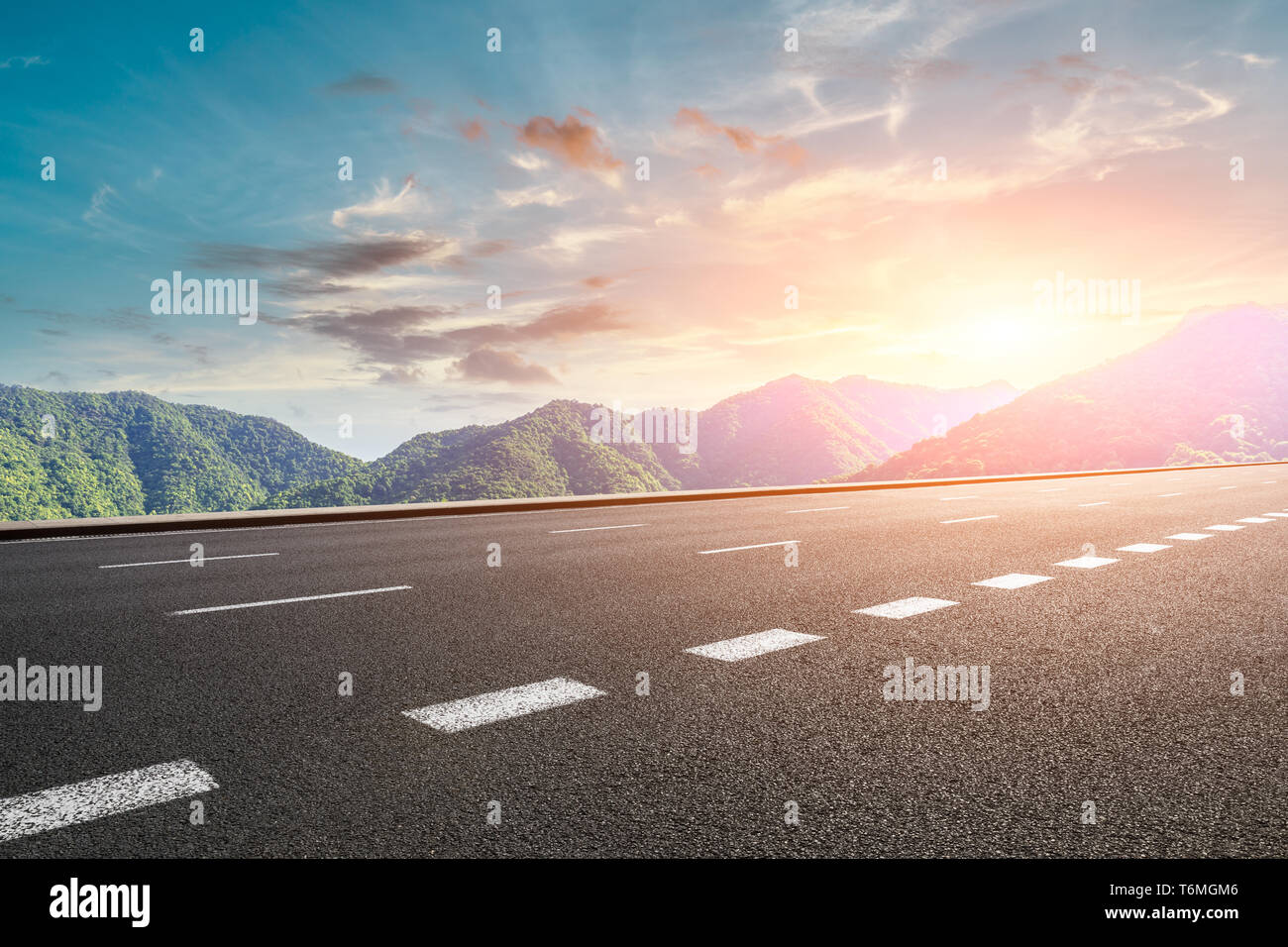 Asphalt highway and beautiful natural landscape at sunset Stock Photo ...