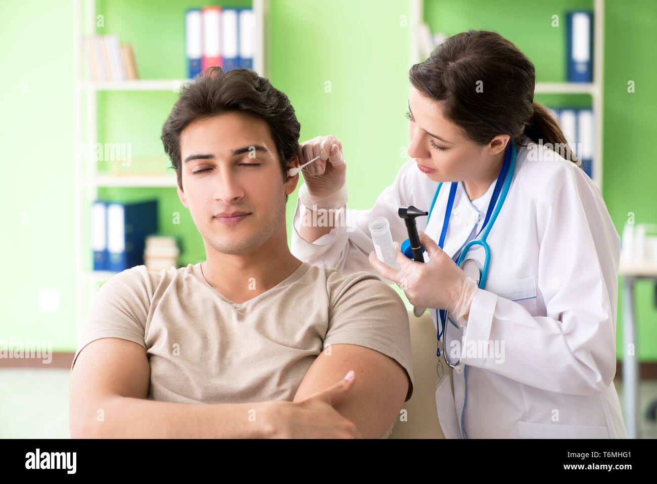 Female doctor checking patient's ear during medical examination Stock ...