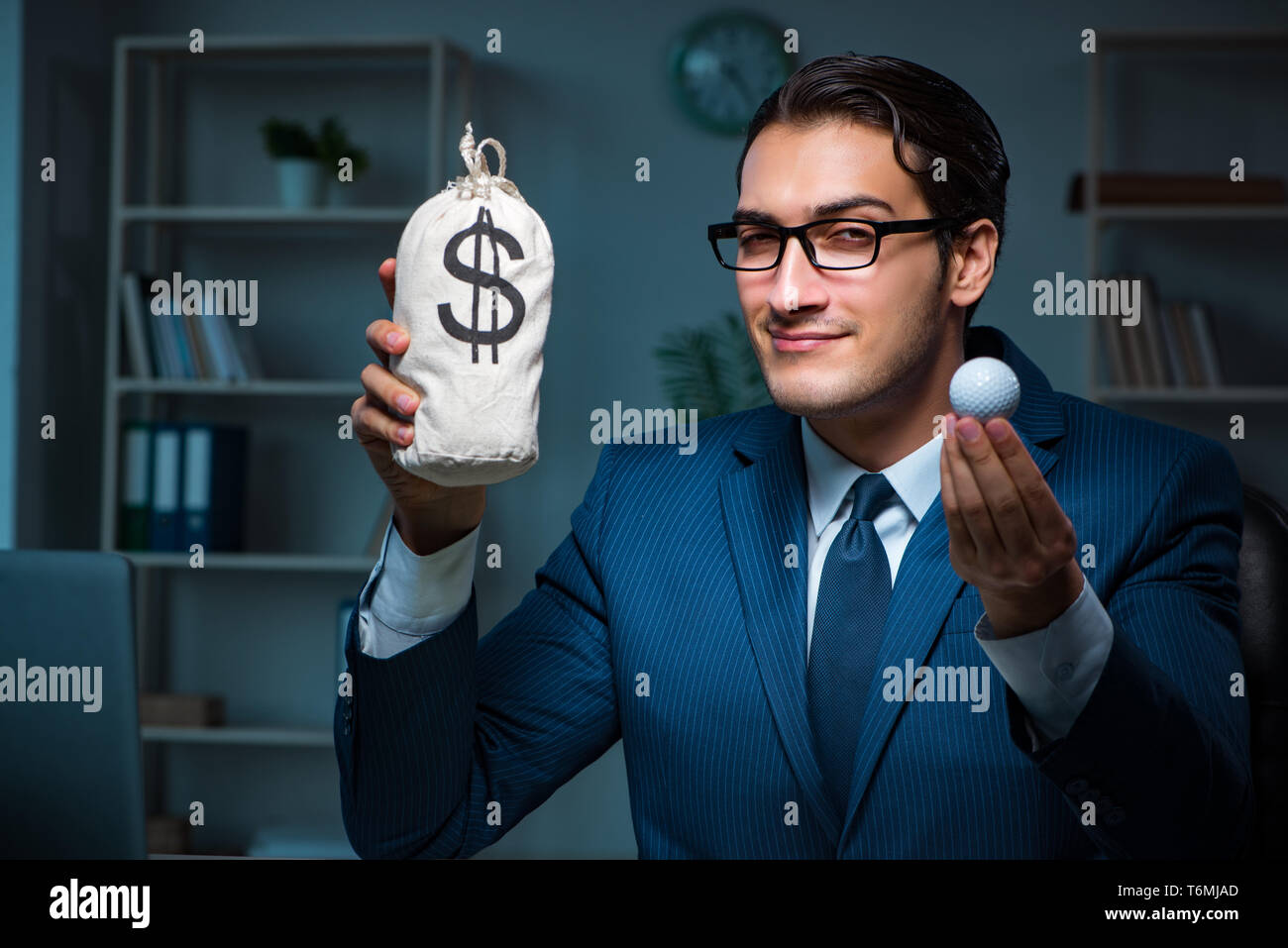 Young employee with golf ball in office Stock Photo - Alamy