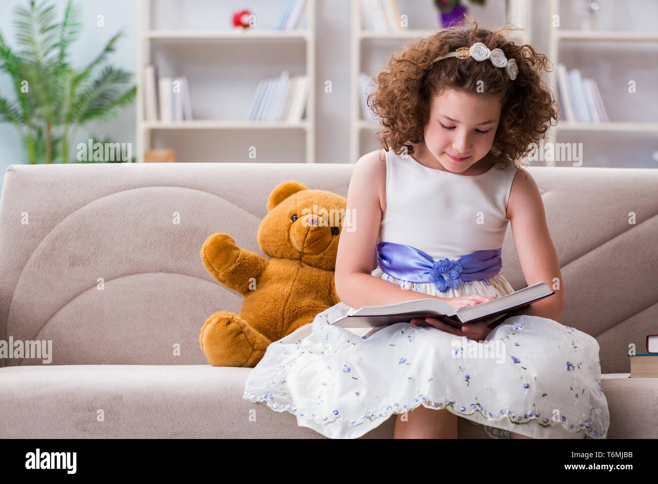 Little pretty girl reading books at home Stock Photo - Alamy