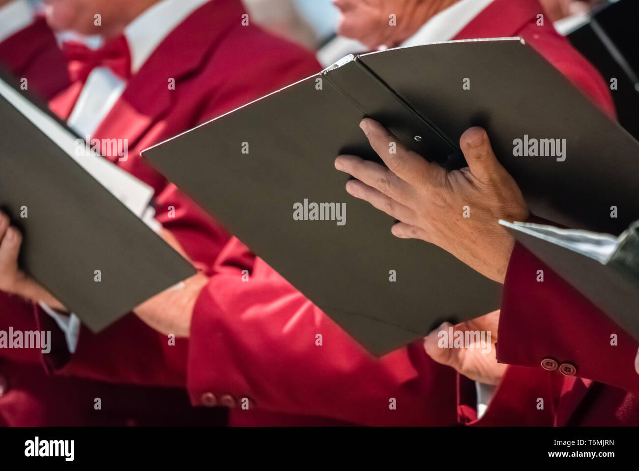 Mens choir members holding singing book Stock Photo - Alamy