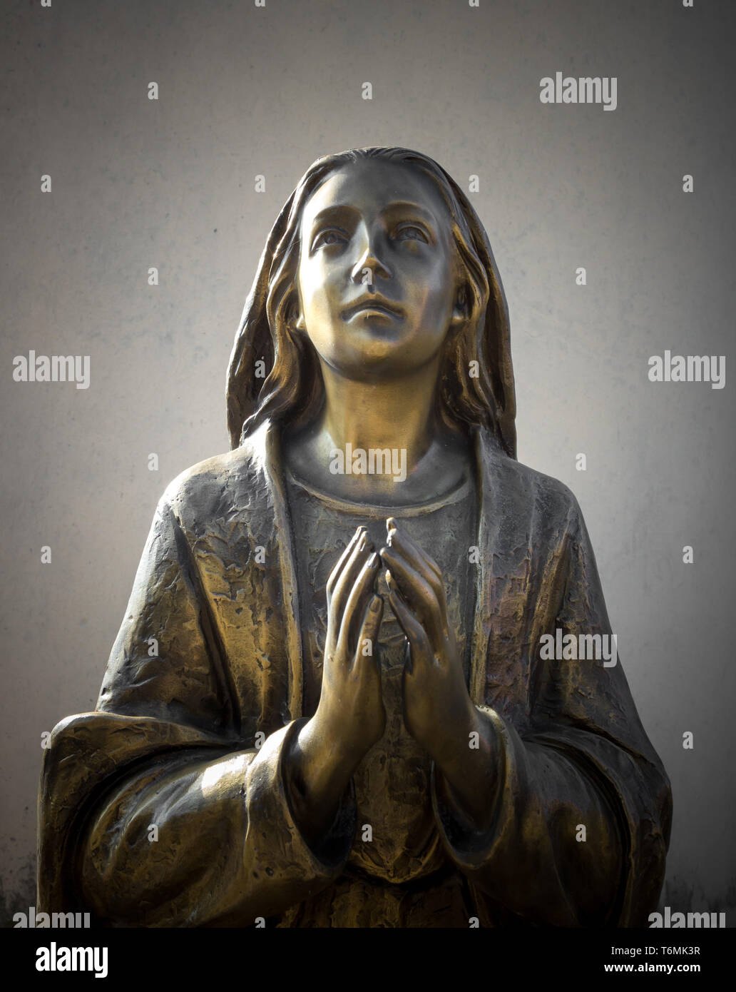 Holy Mary statue bronze that prays with folded hands Stock Photo - Alamy