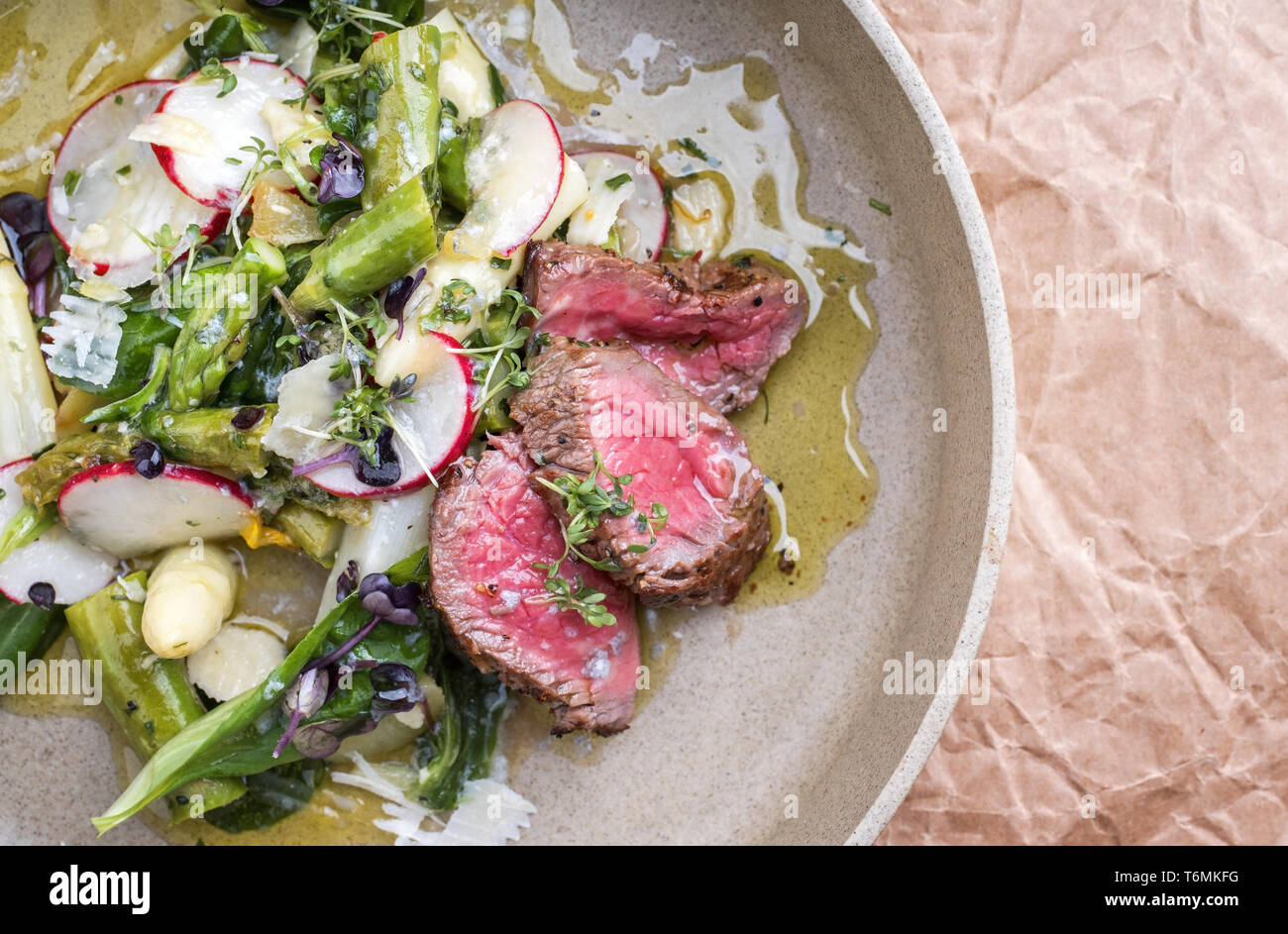 Traditional spring salad with barbecue dry aged sliced fillet steak and ...