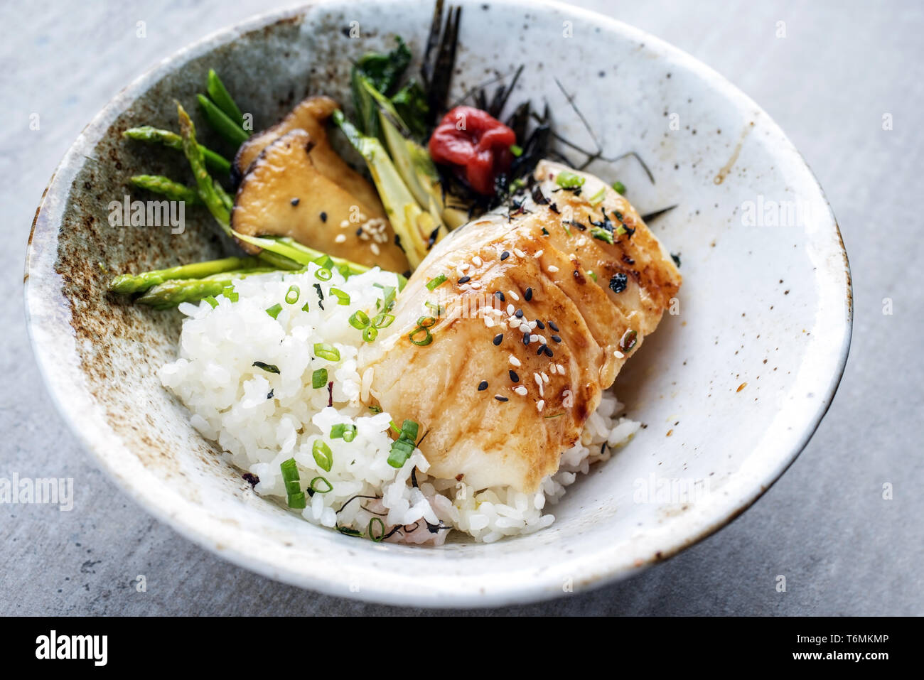 Modern Japanese fried cod fish filet with green asparagus and rice as ...