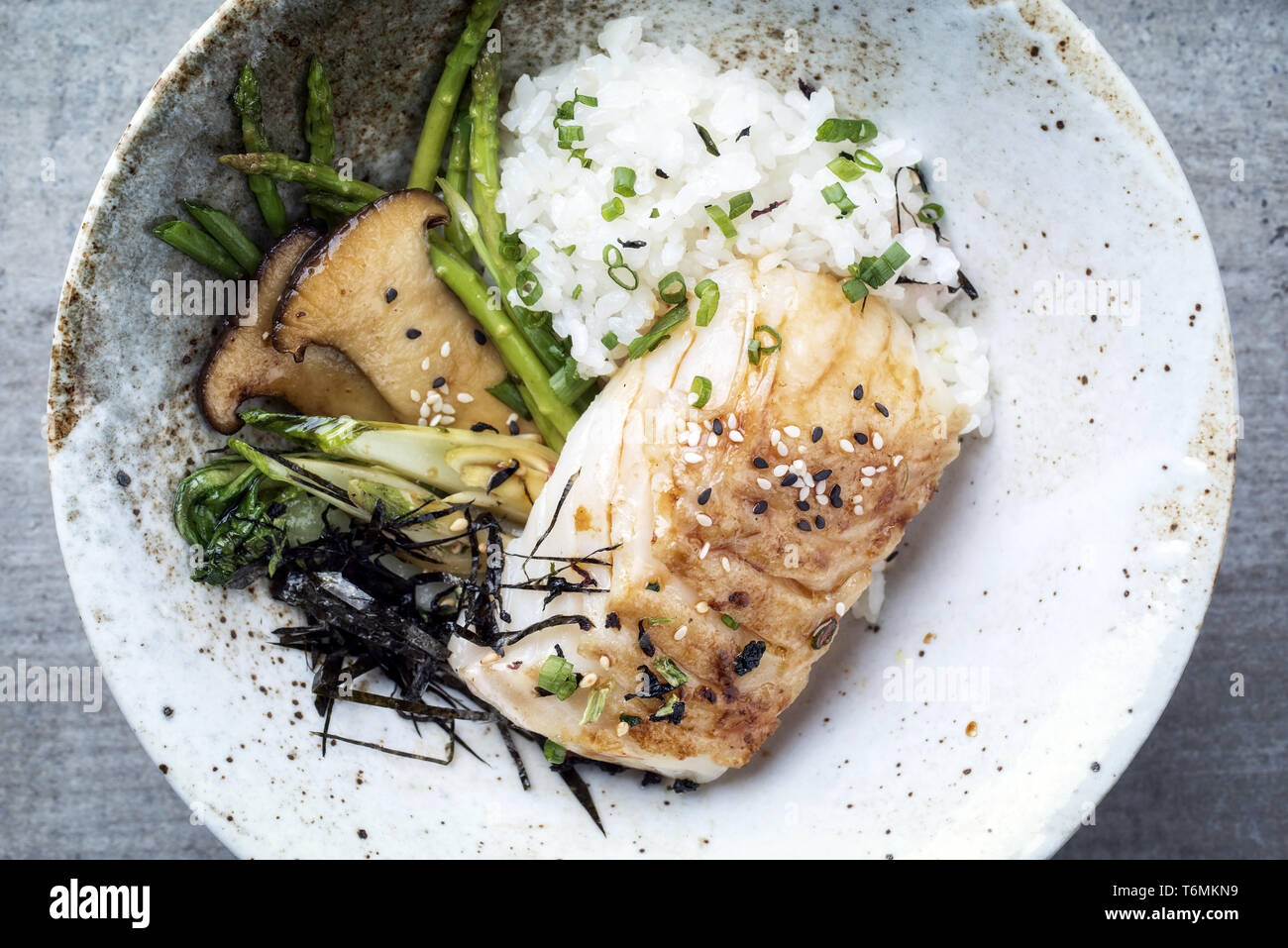 Modern Japanese fried cod fish filet with green asparagus and rice as ...