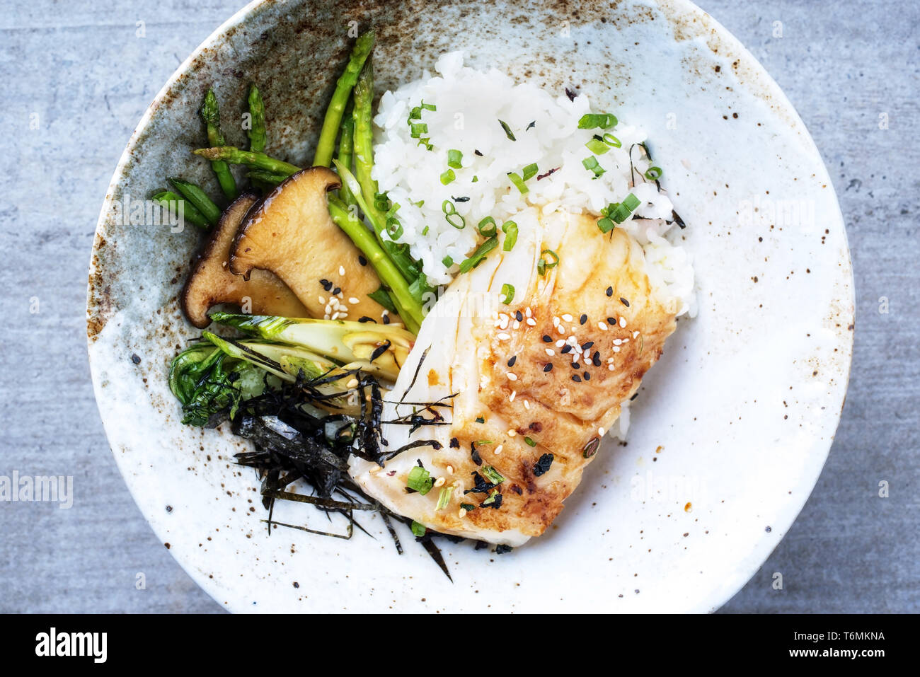 Modern Japanese fried cod fish filet with green asparagus and rice as ...