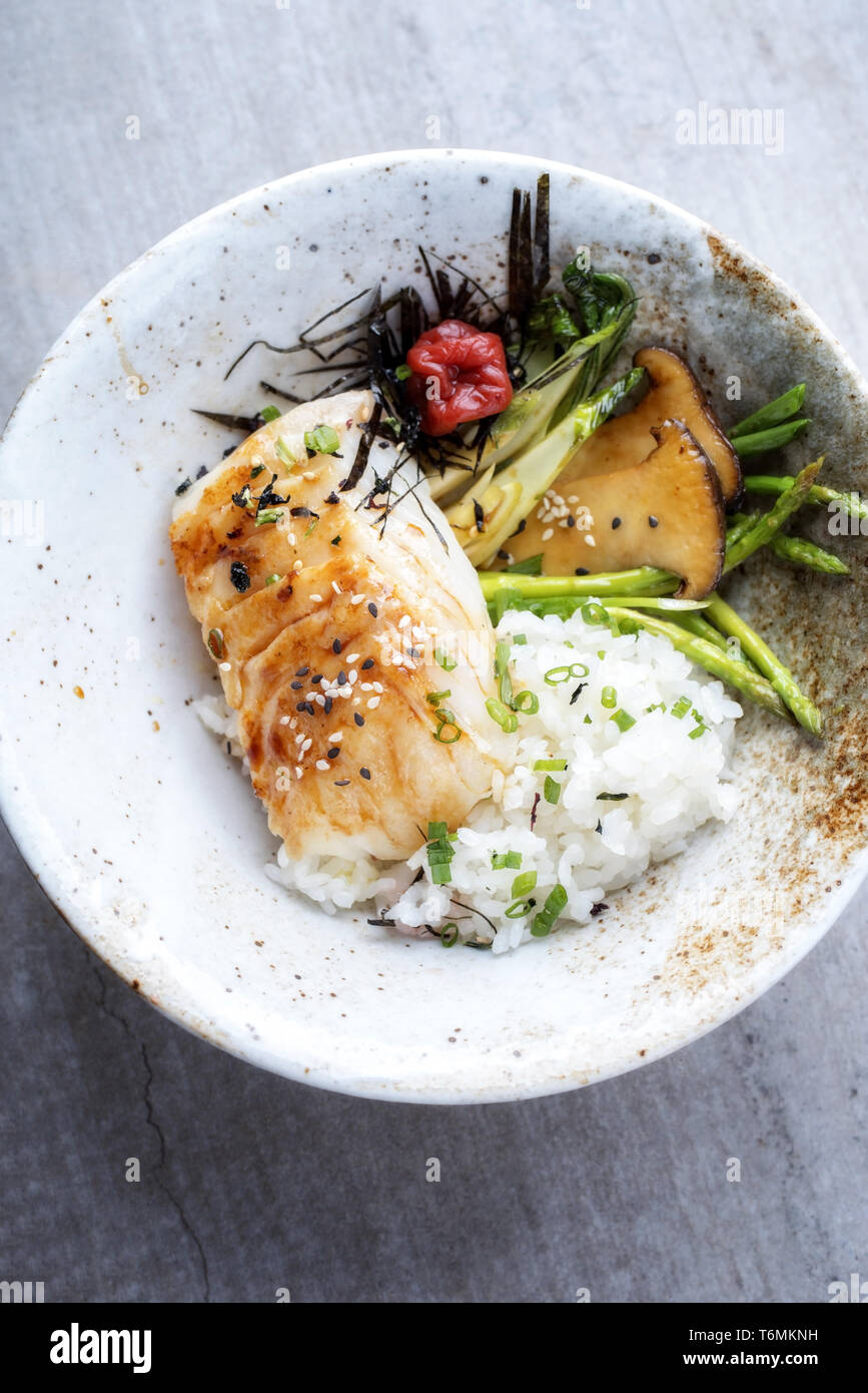 Modern Japanese fried cod fish filet with green asparagus and rice as ...