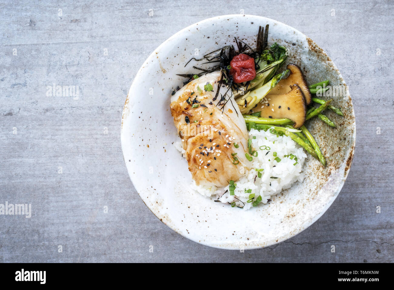Modern Japanese fried cod fish filet with green asparagus and rice as ...