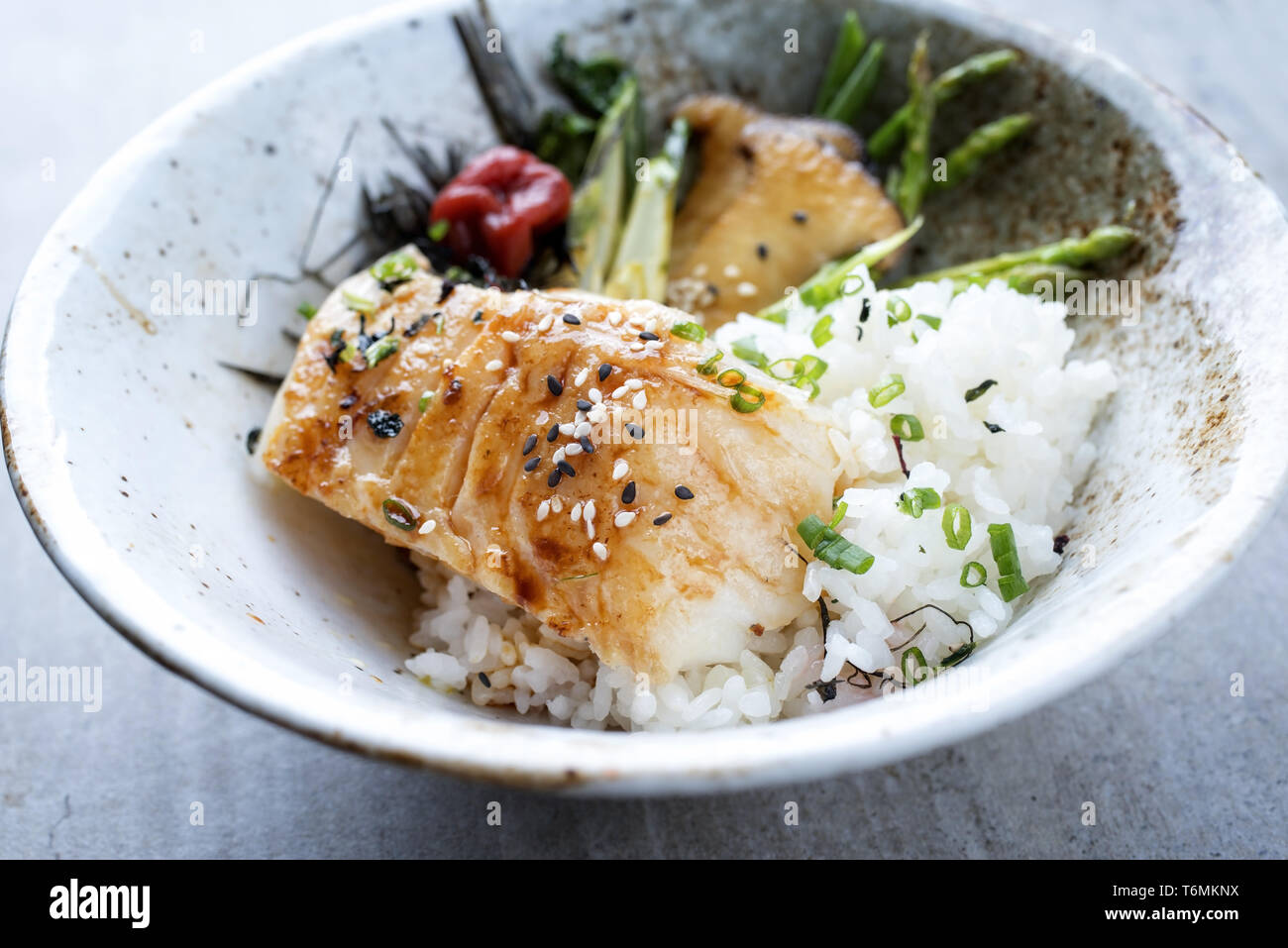 Modern Japanese fried cod fish filet with green asparagus and rice as ...