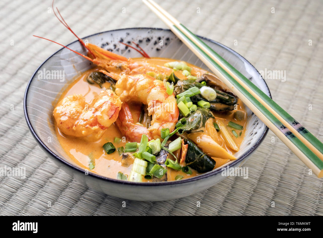 Traditional Thai kaeng phet red curry with king prawns and vegetable as ...
