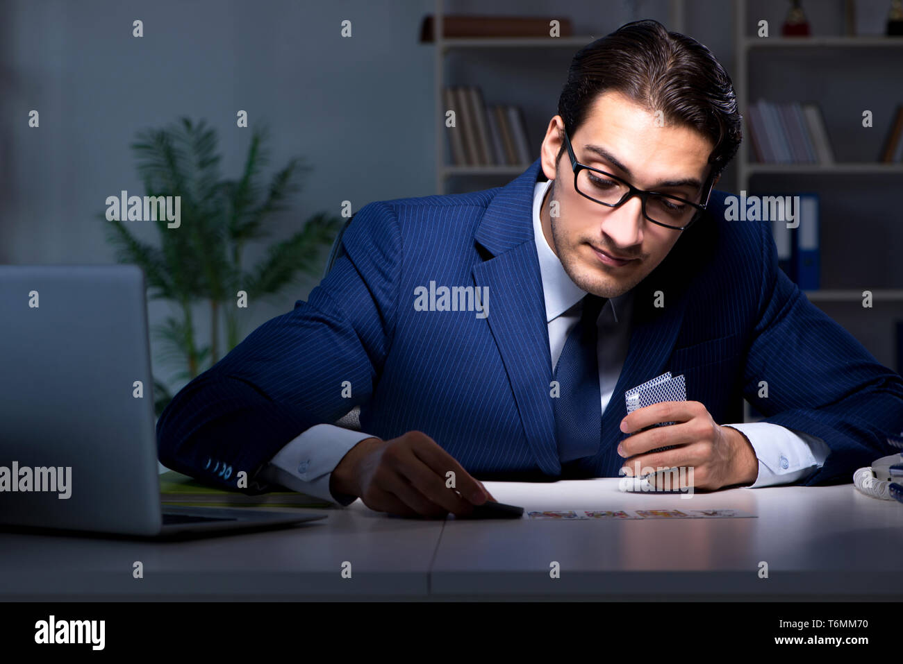 Young business playing cards late in office Stock Photo - Alamy