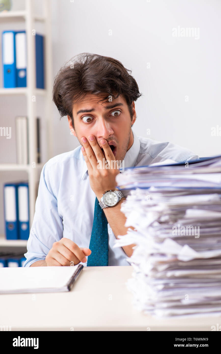Overloaded busy employee with too much work and paperwork Stock Photo ...