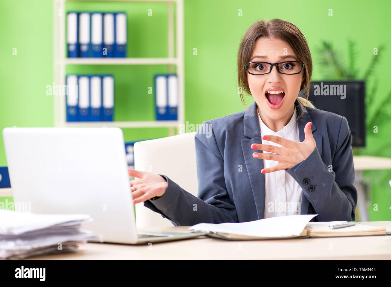 Young female employee very busy with ongoing paperwork Stock Photo - Alamy