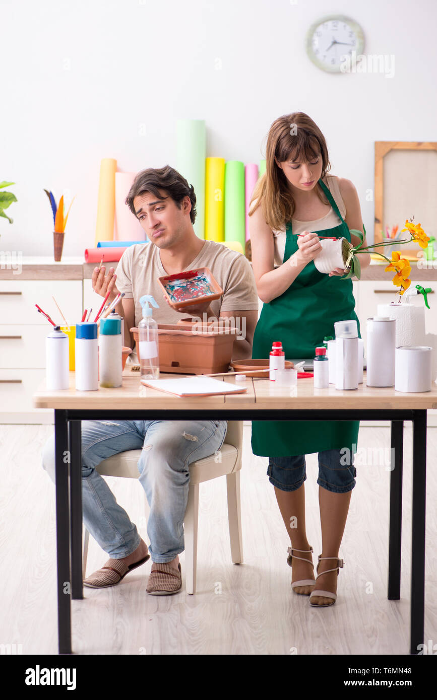 Couple decorating pots in workshop during class Stock Photo - Alamy