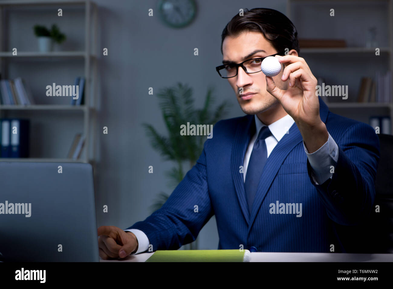 Young employee with golf ball in office Stock Photo - Alamy