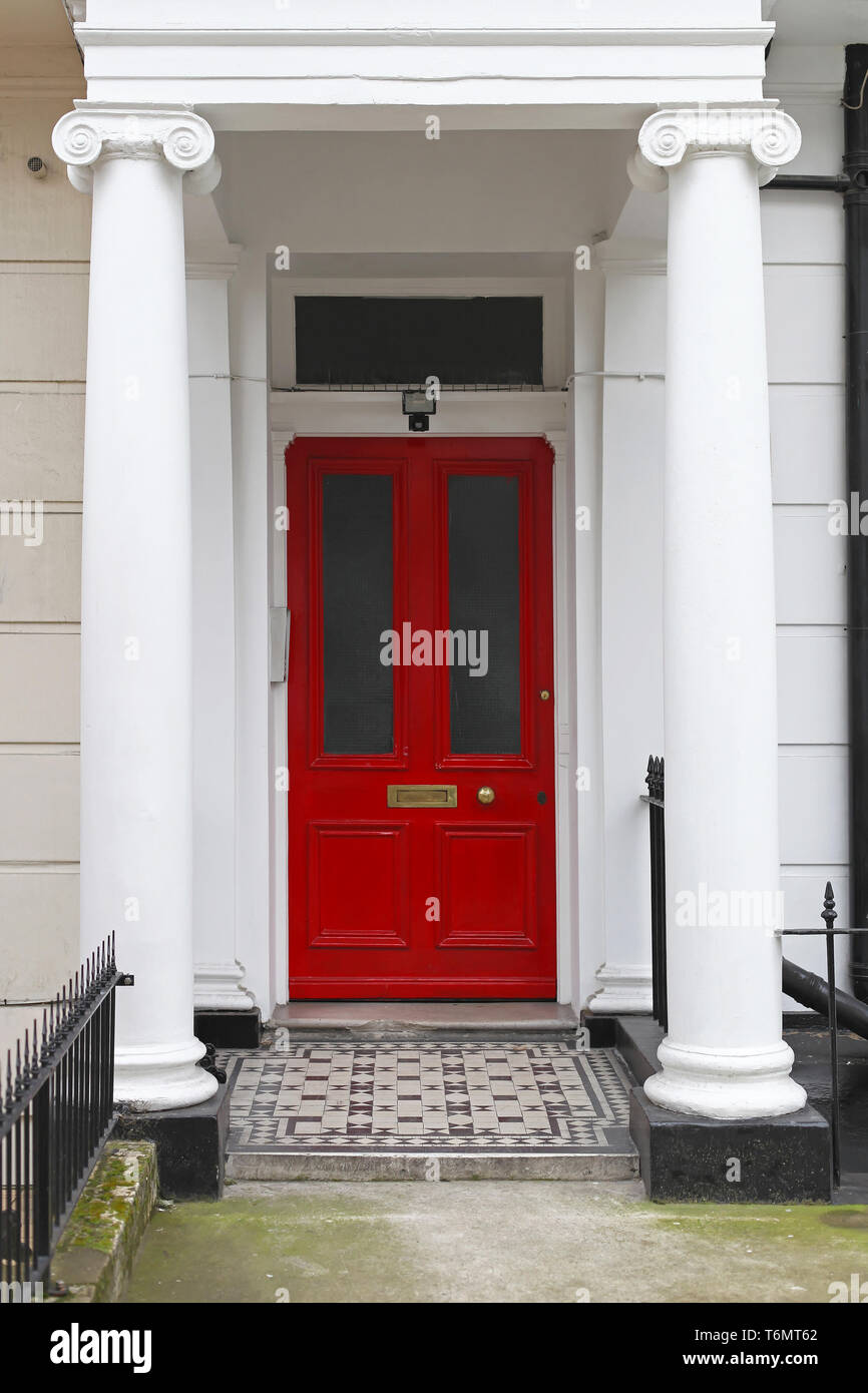 Red door at Victorian house with columns Stock Photo - Alamy