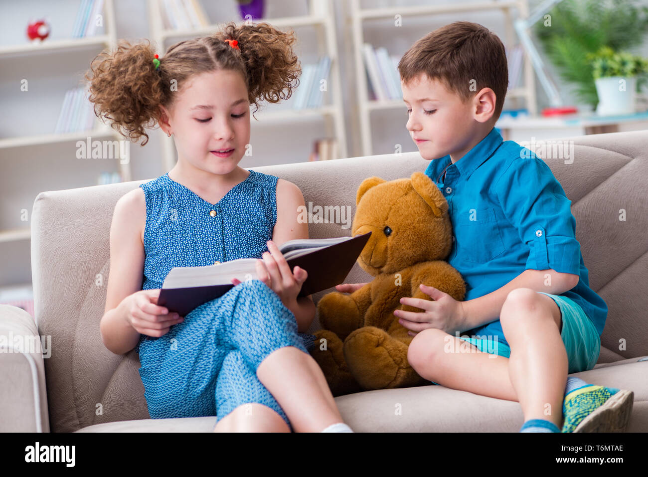 Two kids reading books at home Stock Photo - Alamy