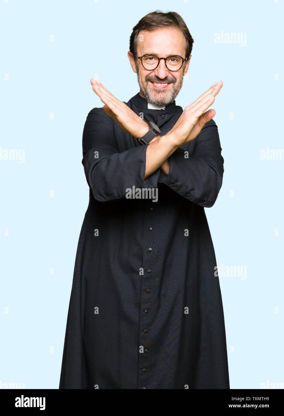 Middle age priest man wearing catholic robe Rejection expression ...